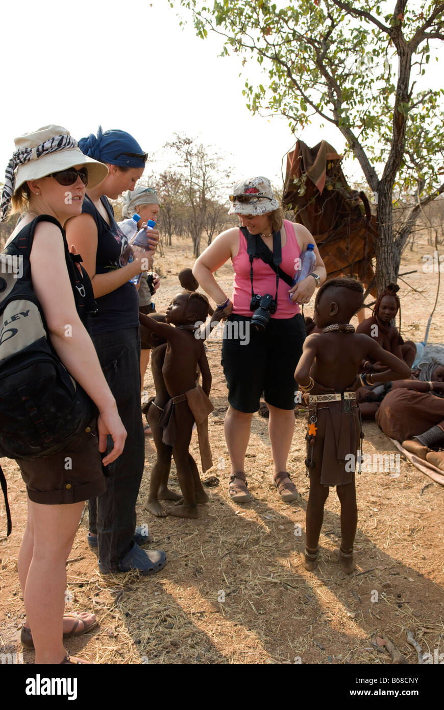 Western travellers meet local people at the the Himba Oase Village near ...