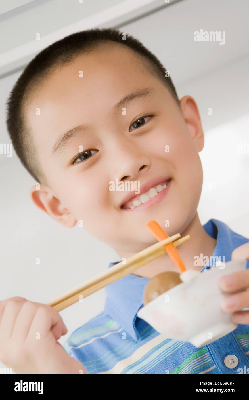 Portrait of a boy eating noodles with chopsticks Stock Photo - Alamy