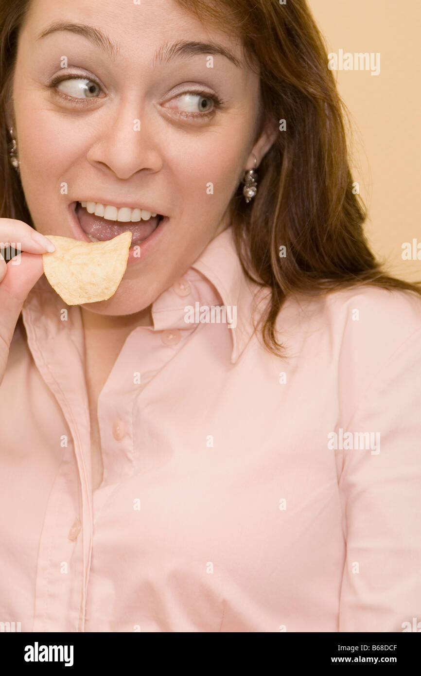 Close-up of a mid adult woman eating a potato chip Stock Photo - Alamy