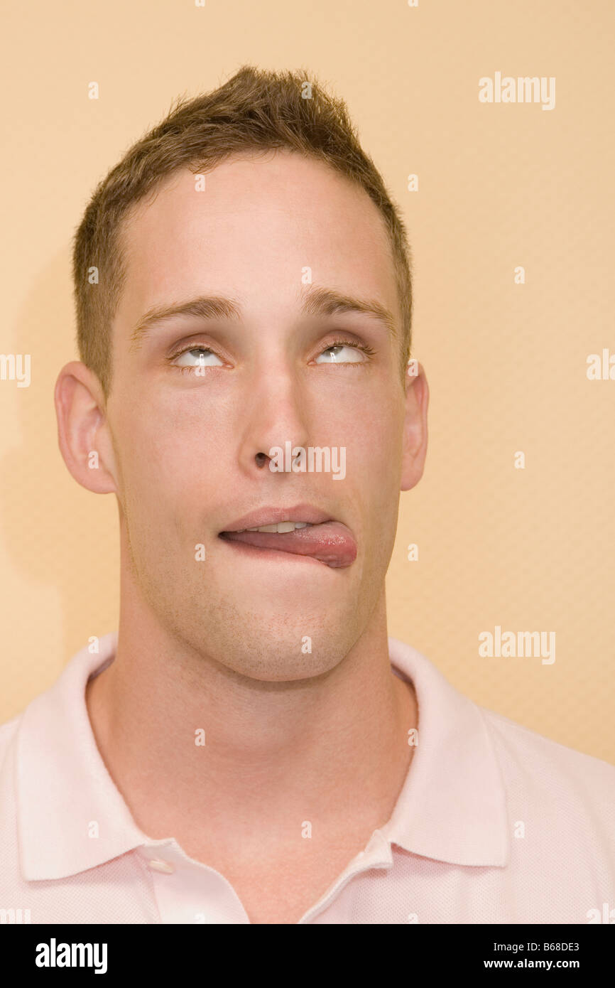 Close-up of a young man sticking his tongue out Stock Photo - Alamy