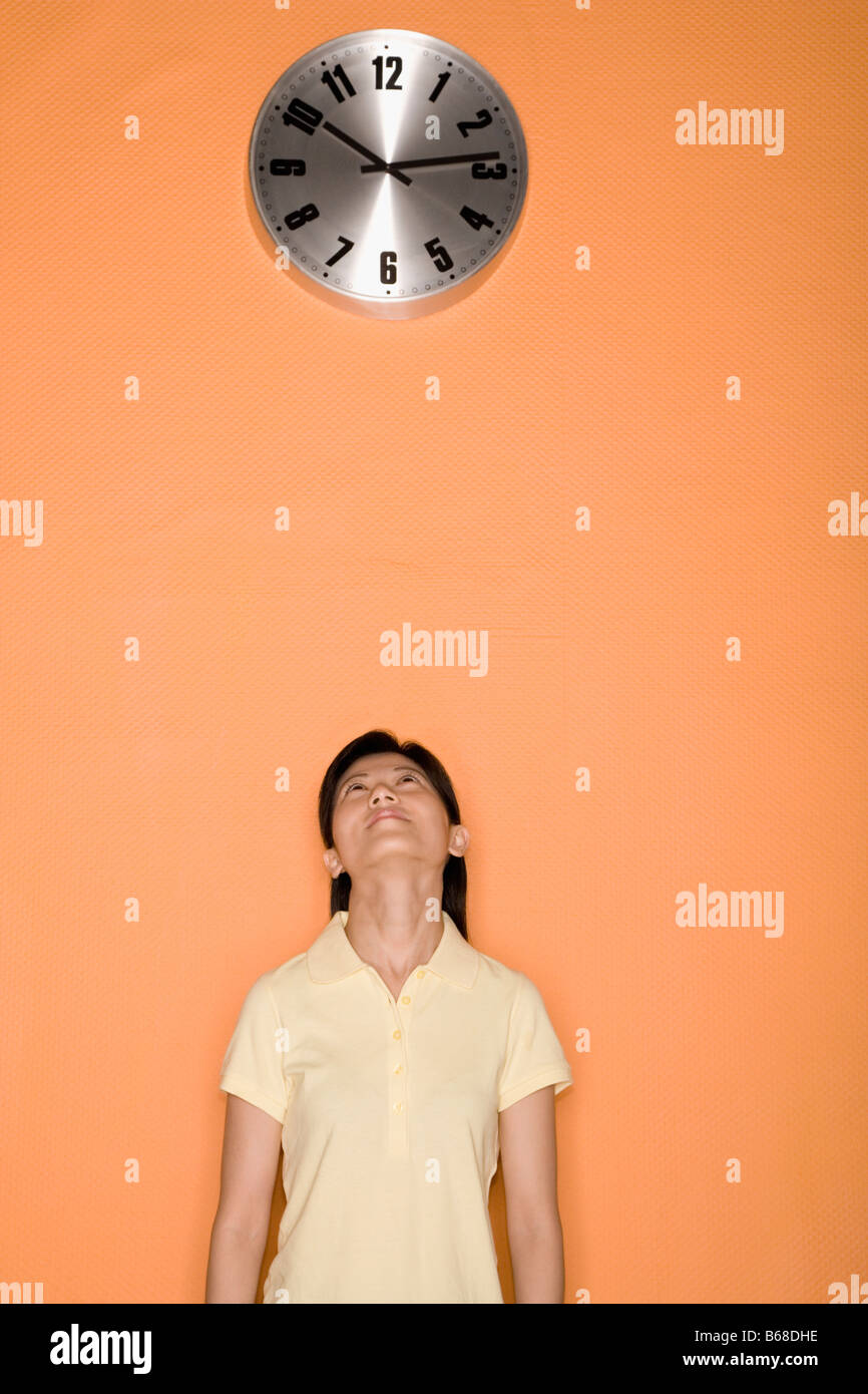 Female office worker looking at a clock Stock Photo - Alamy
