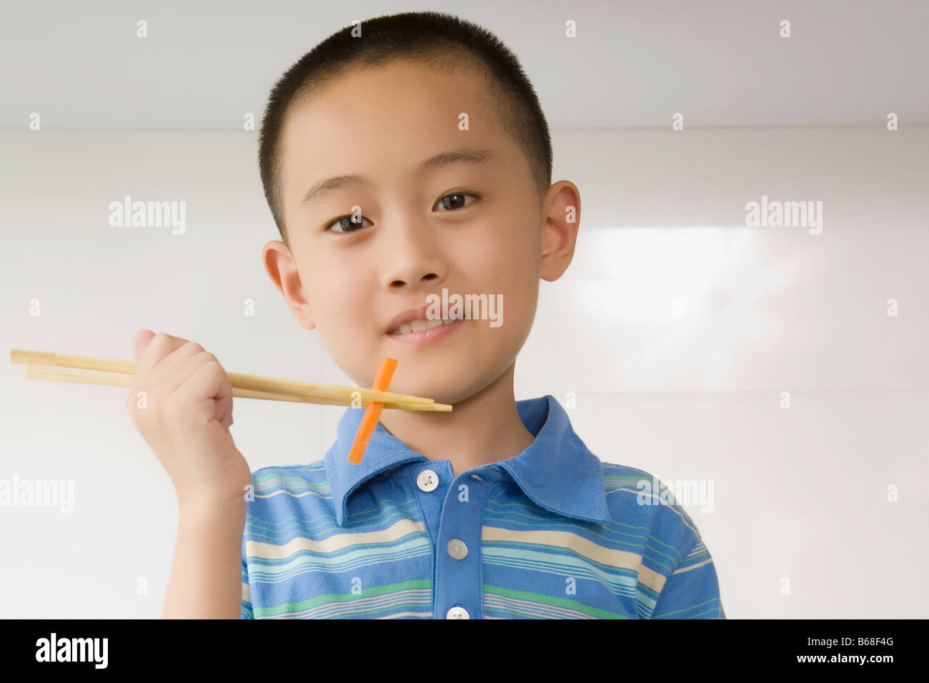Portrait of a boy eating noodles with chopsticks Stock Photo - Alamy