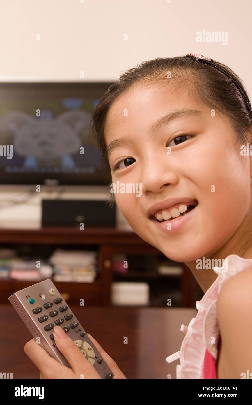 Portrait of a girl holding a remote control and smiling Stock Photo - Alamy