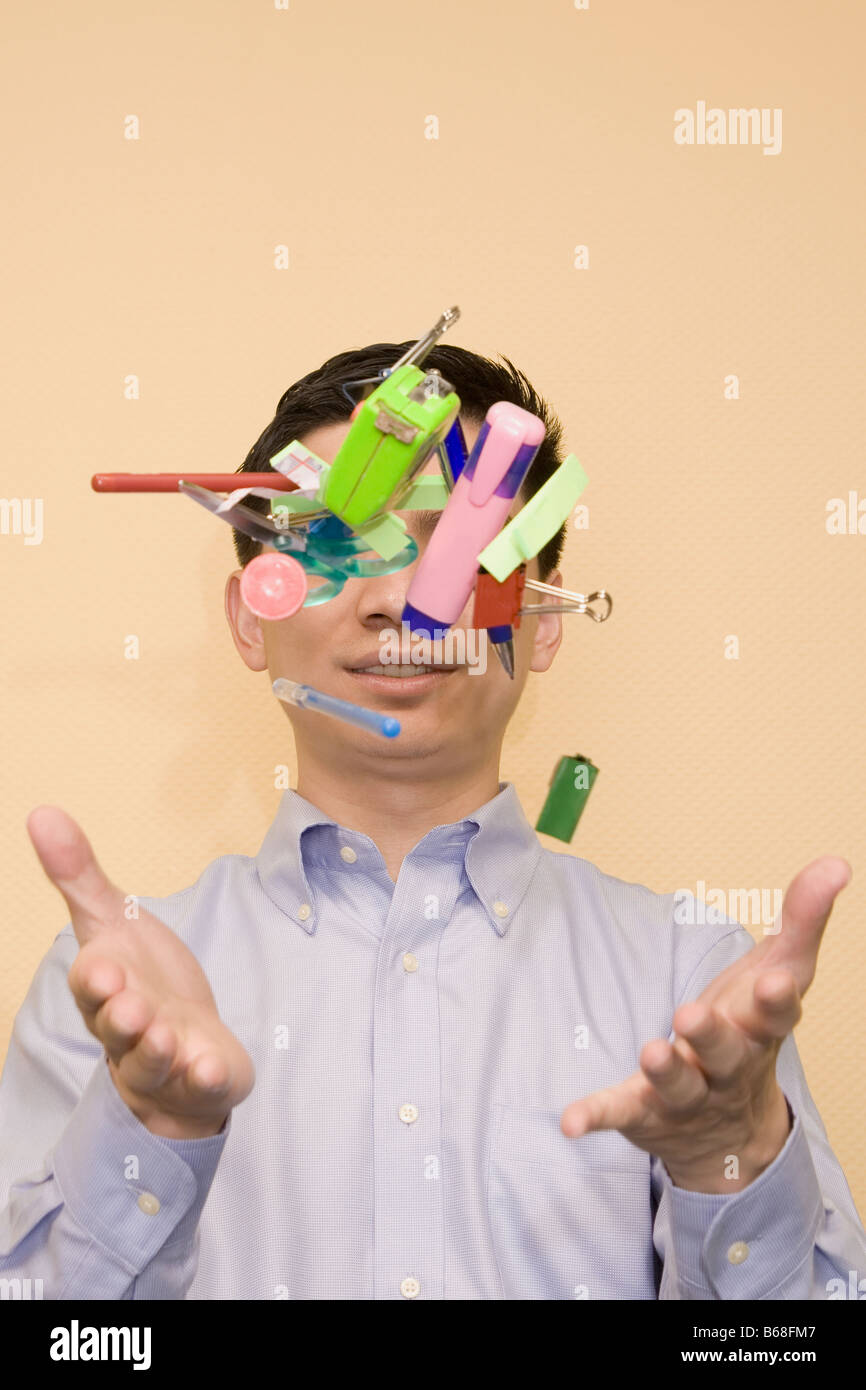 Close-up of a young man tossing stationery objects Stock Photo - Alamy