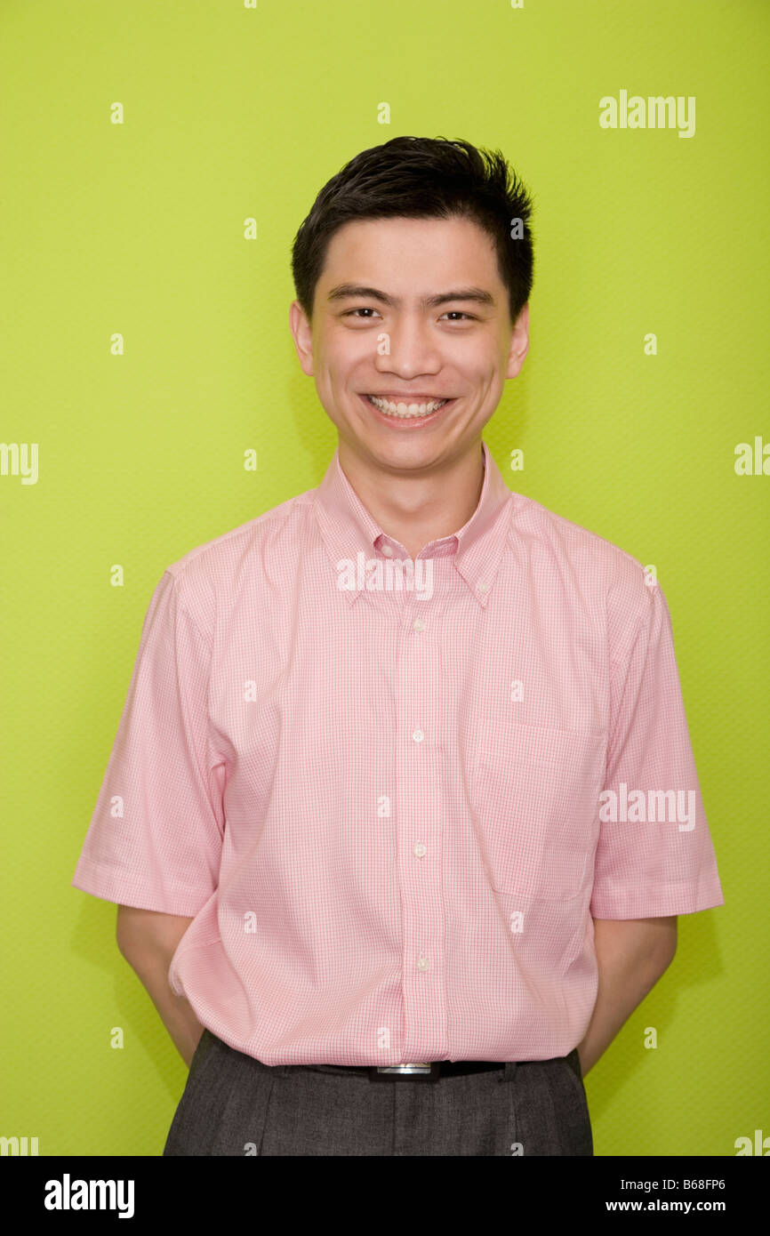 Portrait of a male office worker standing with his hands behind his ...