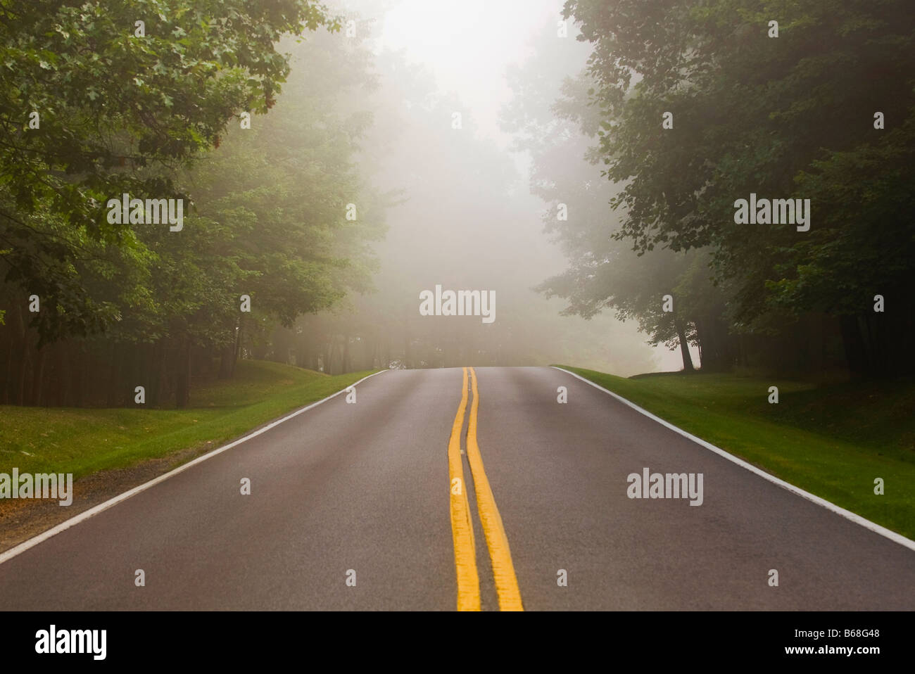 mountain road cresting a hill, foggy day Stock Photo - Alamy