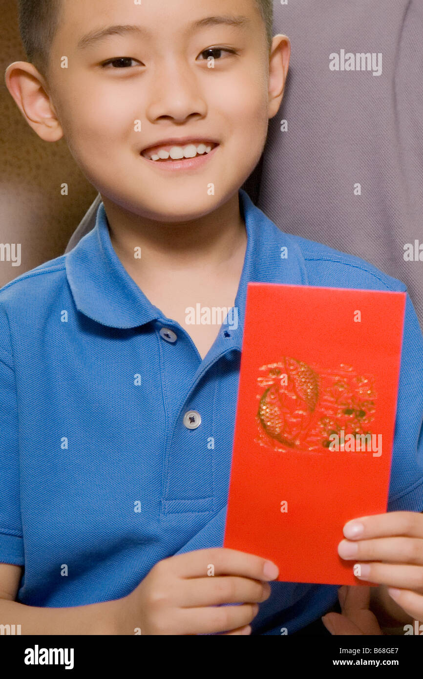 Portrait of a boy showing a red gift envelope Stock Photo - Alamy