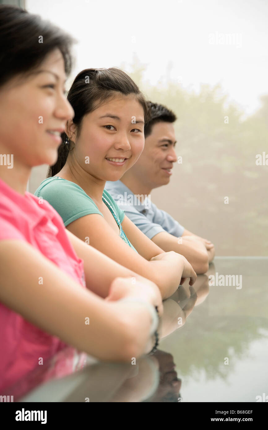 Side profile of three office workers sitting at a conference table and ...