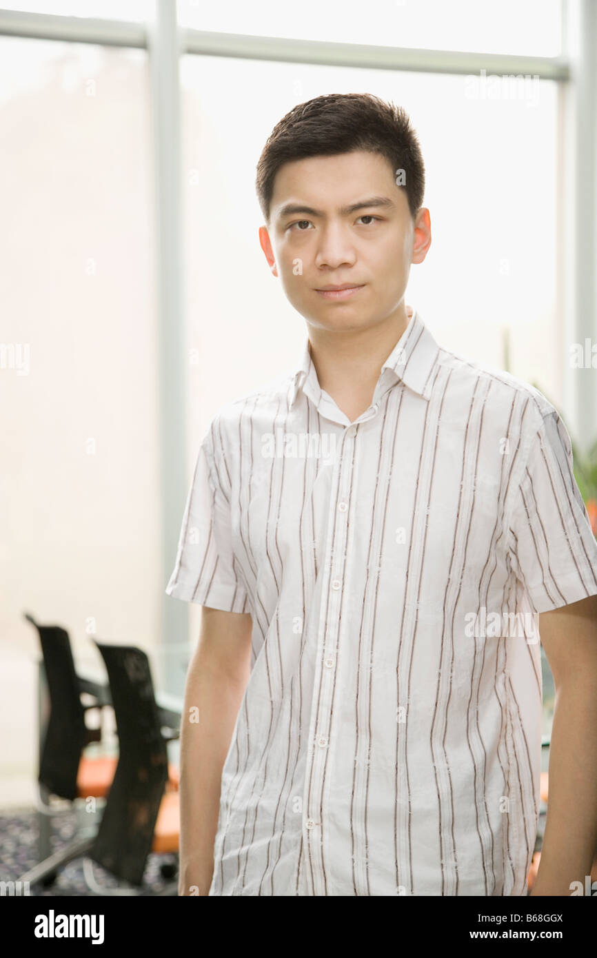 Portrait of a male office worker standing in an office Stock Photo - Alamy
