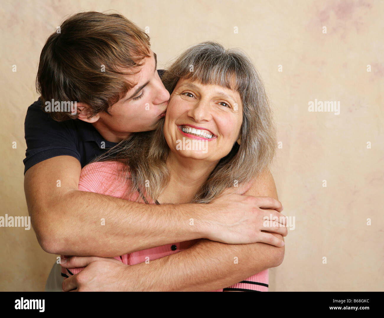 Young Adult Late Teen Son Kissing His Mother On The Cheek Stock Photo