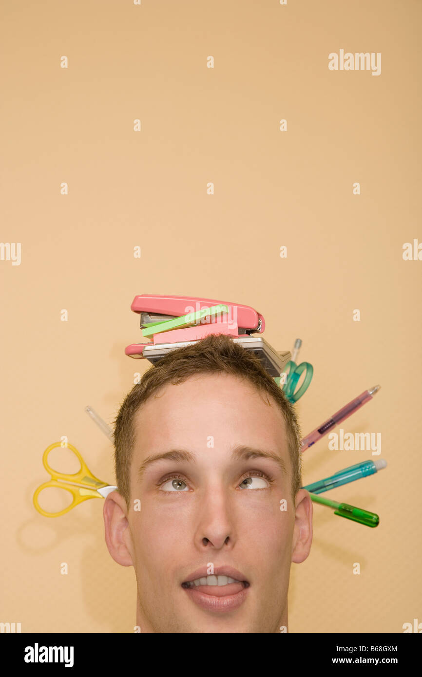 Close-up of a young man with stationery objects on his head Stock Photo ...