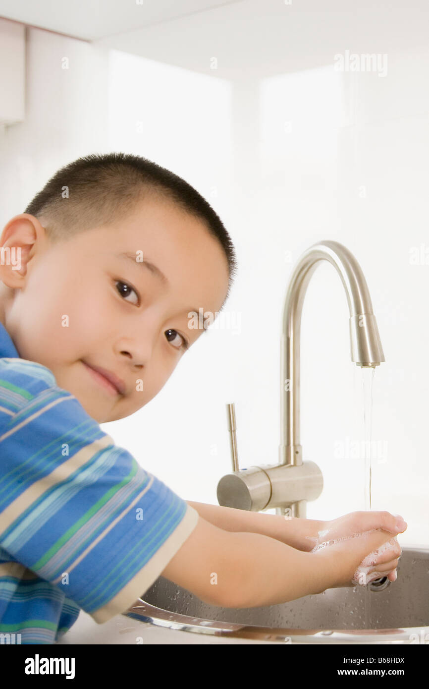 Portrait of a boy washing his hands in a wash basin Stock Photo - Alamy
