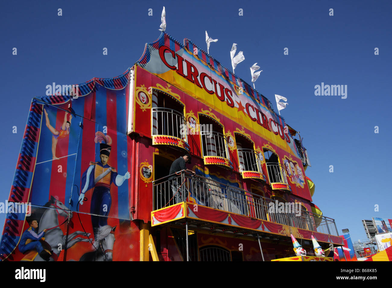 BRIGHTLY COLOURED CIRCUS FAIRGOUND ATTRACTION AGAINST BLUE SKY ...