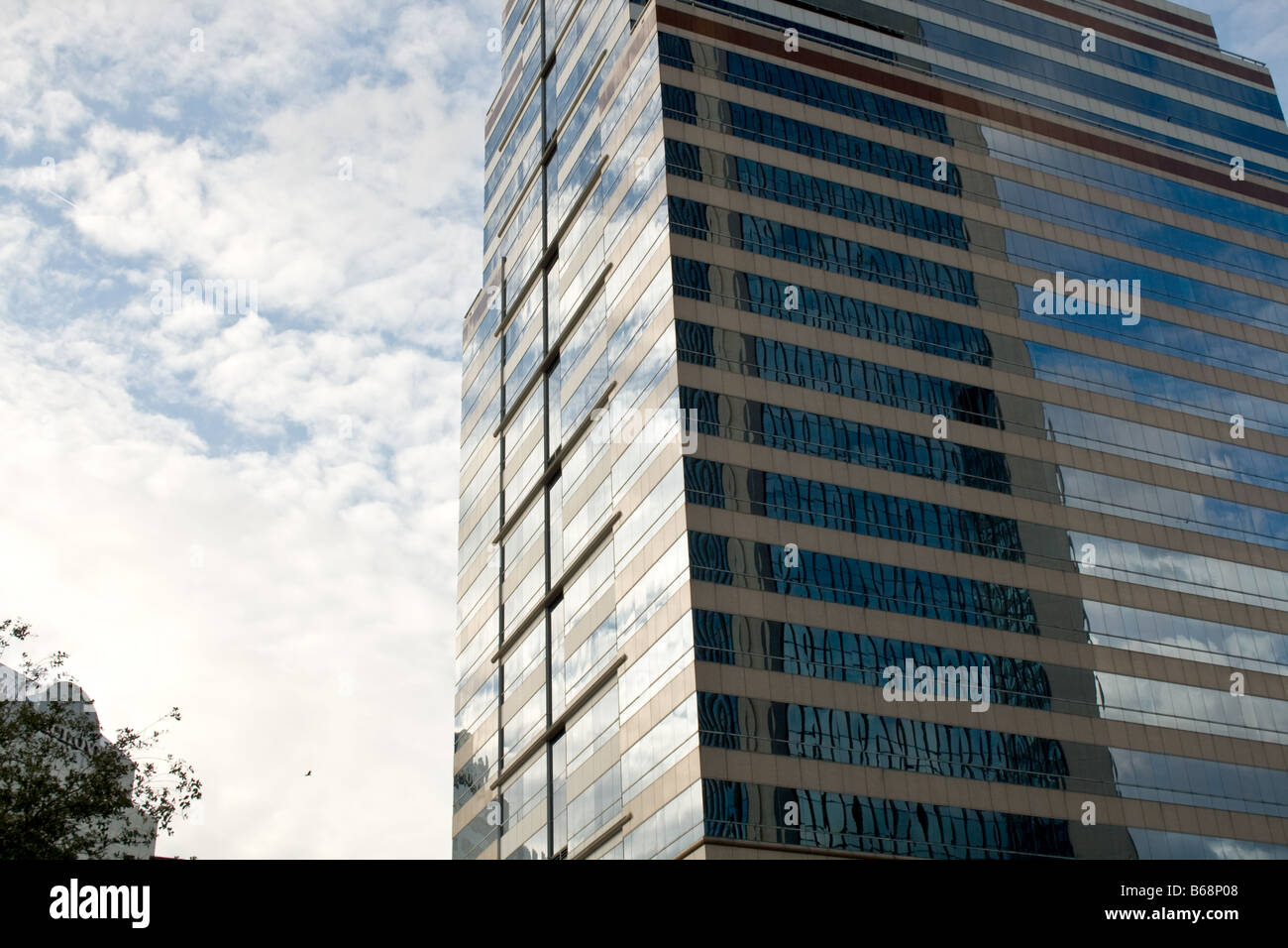 Tall skyscraper building with mirror windows with bright blue sky in ...