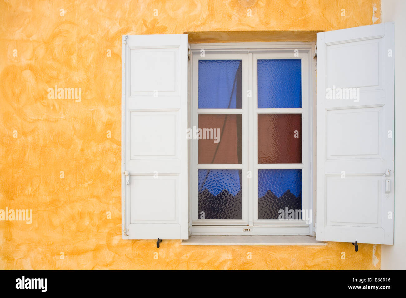 Colorful window of a bright yellow Greek house Stock Photo - Alamy