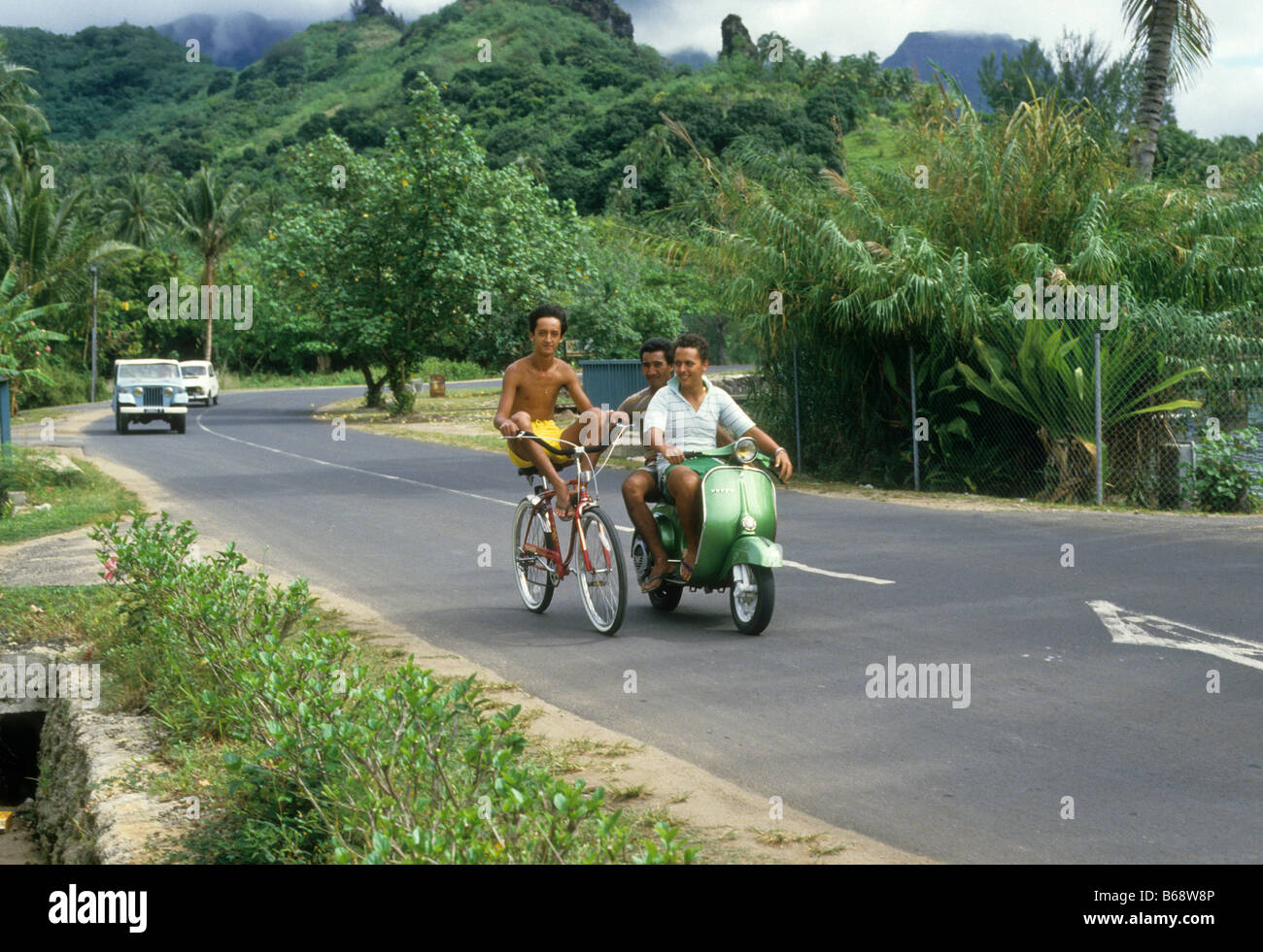 Teen boy on bike get pulled by other boys on motor scooter South ...