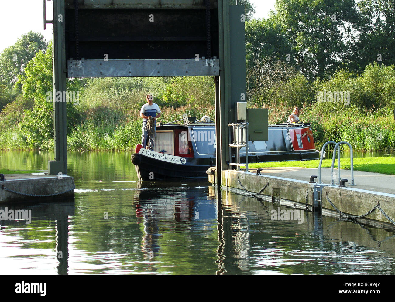 A narrow boat entering a river lock through the raised lock gate Stock ...