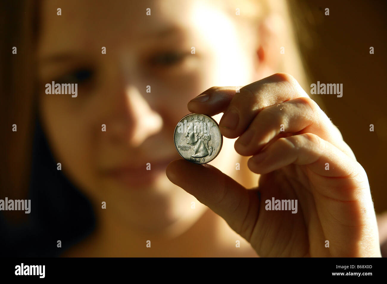 Girl holding coin Stock Photo - Alamy