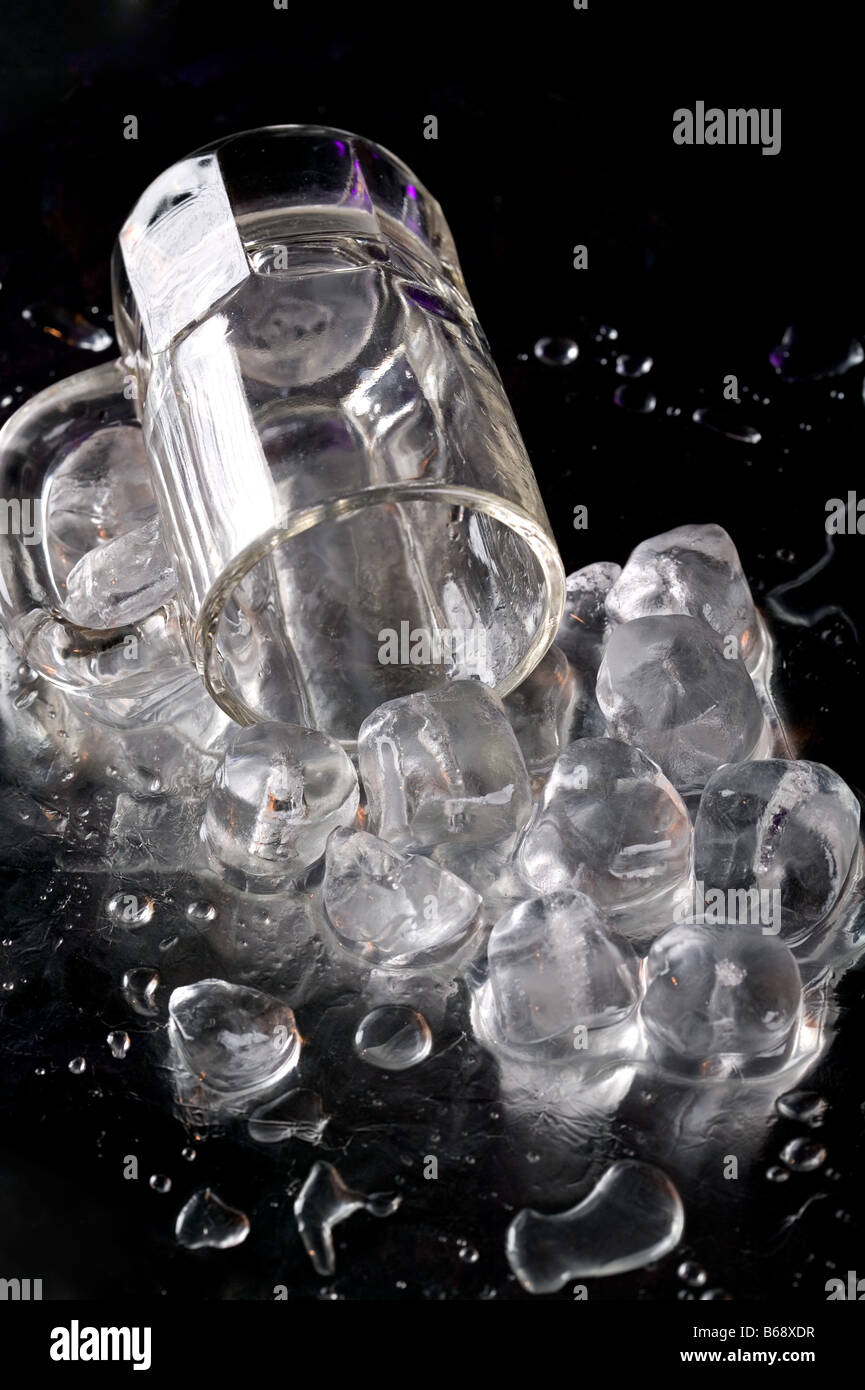 A cold mug spilling melting ice cubes Stock Photo - Alamy
