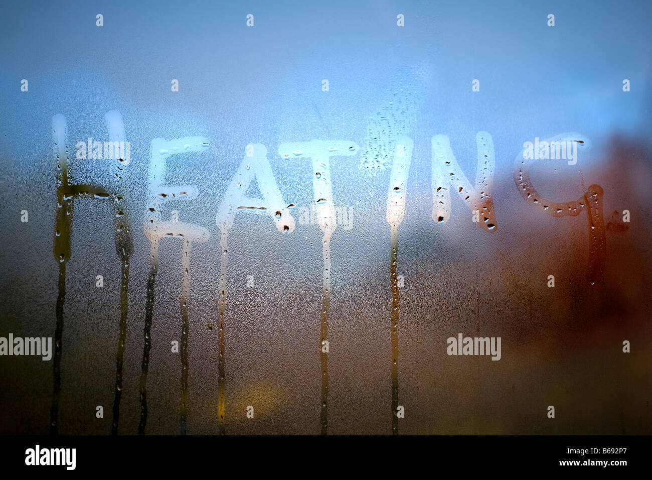 Condensation on a window showing the word heating drawn into the water ...