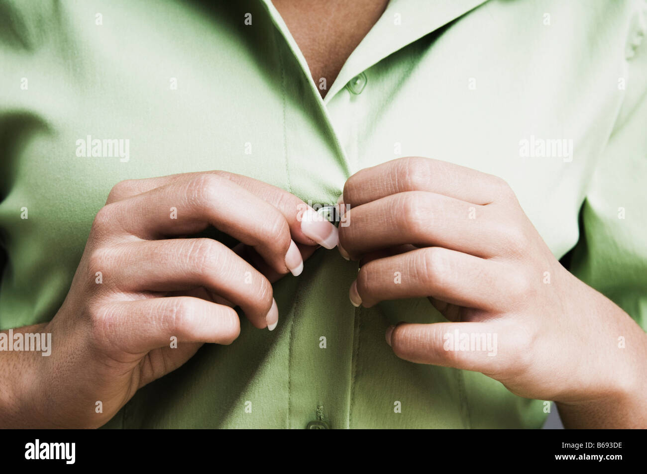 Woman buttoning shirt, close-up Stock Photo - Alamy