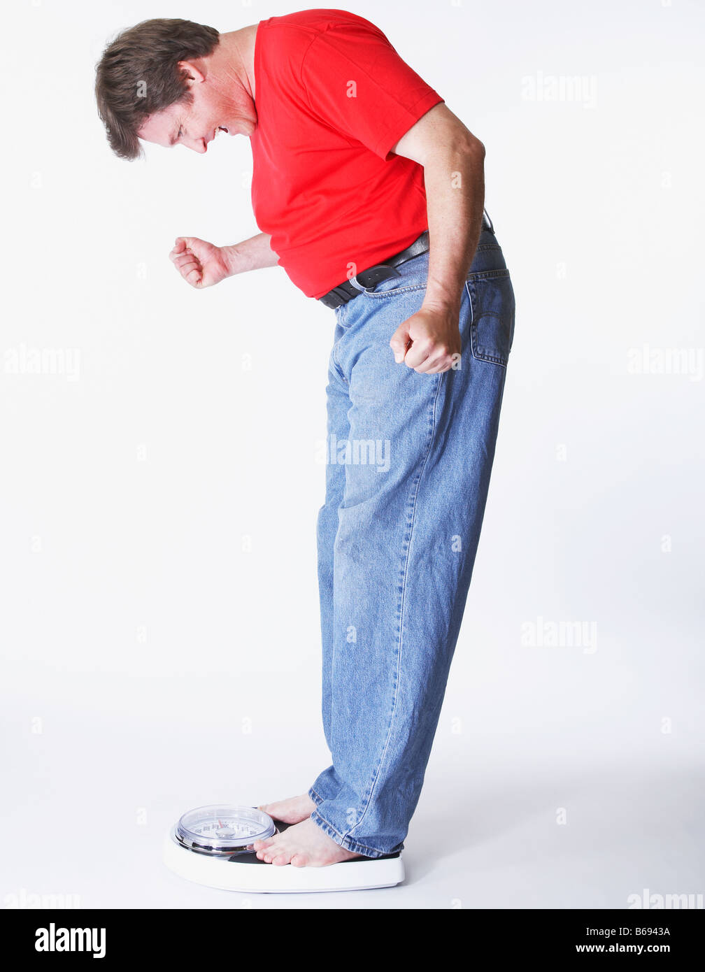 Man standing on weight scales, cheering Stock Photo - Alamy
