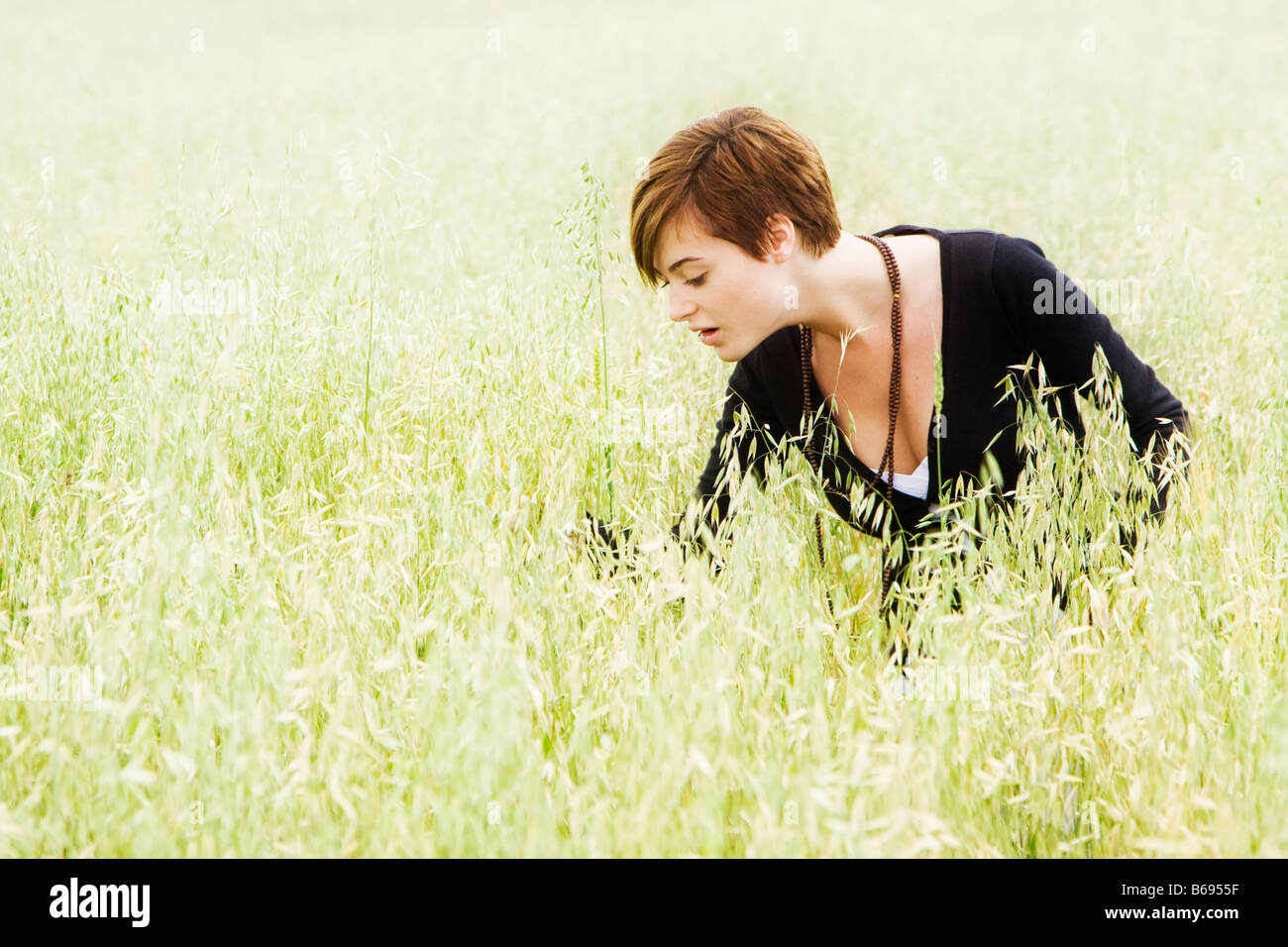 Woman on field observing something Stock Photo - Alamy