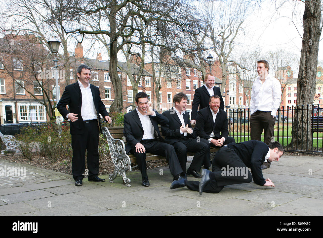 Seven 7 businessmen sat and stood around a city centre bench Stock ...