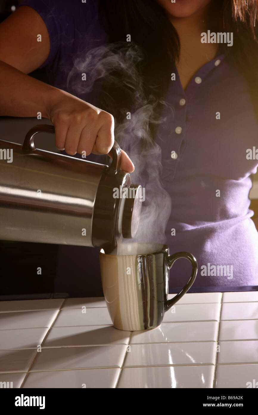 Teen pouring steaming hot tea into a mug Stock Photo - Alamy