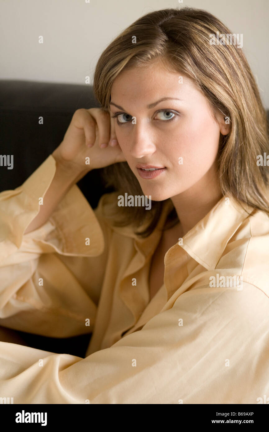 Young woman sitting on couch portrait Stock Photo - Alamy