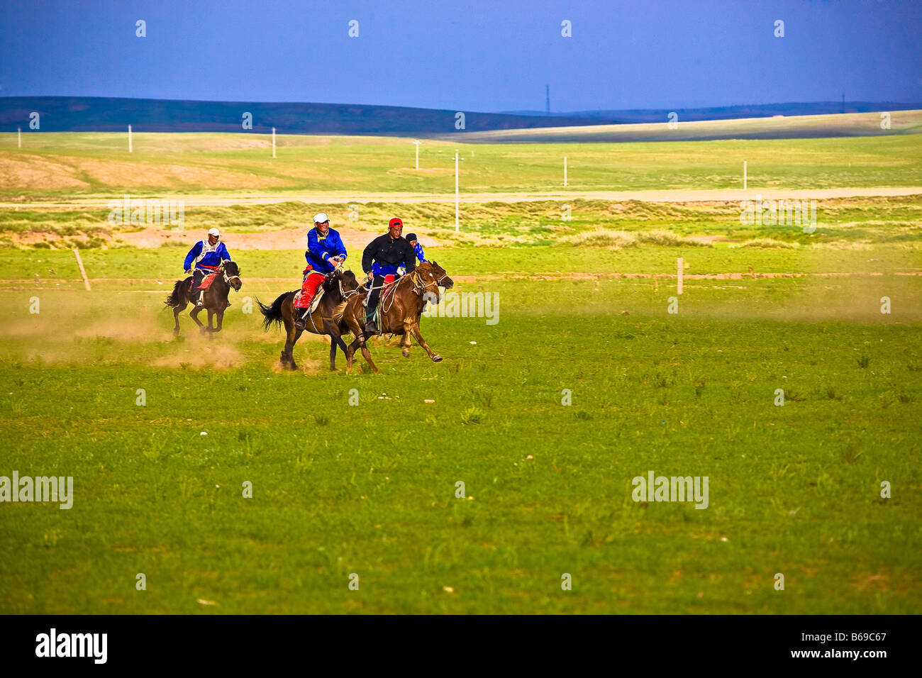 Four people horseback riding in a field, Inner Mongolia, China Stock ...