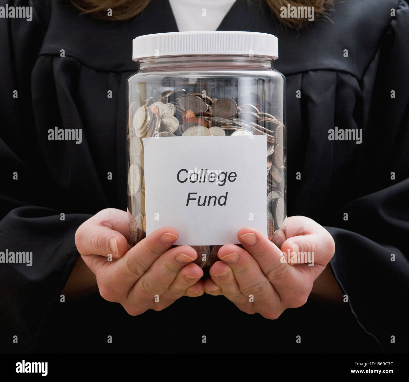 Graduate student holding college fund in jar, mid section Stock Photo ...