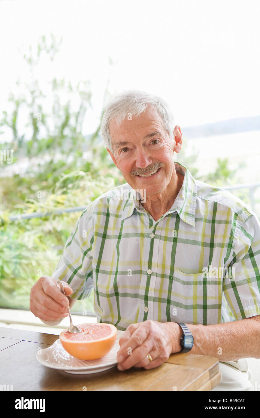 Man eating a grapefruit Stock Photo - Alamy