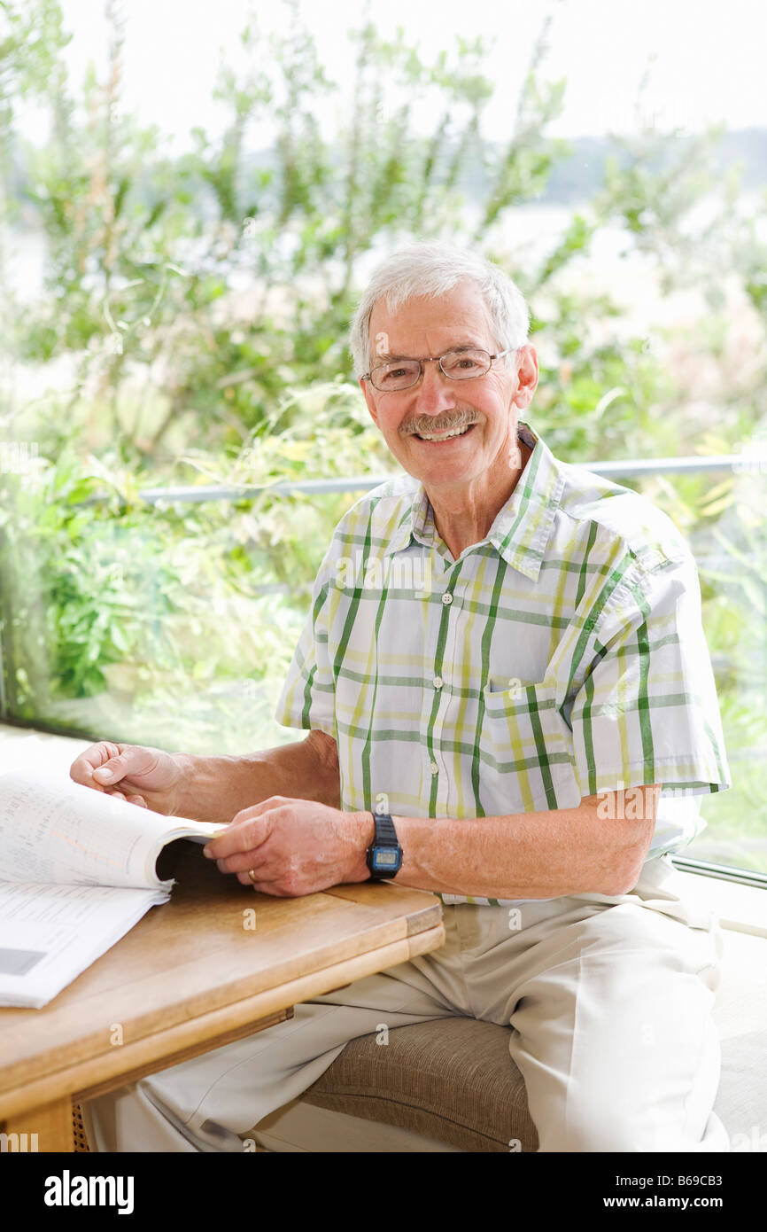Man reading a magazine and smiling Stock Photo - Alamy