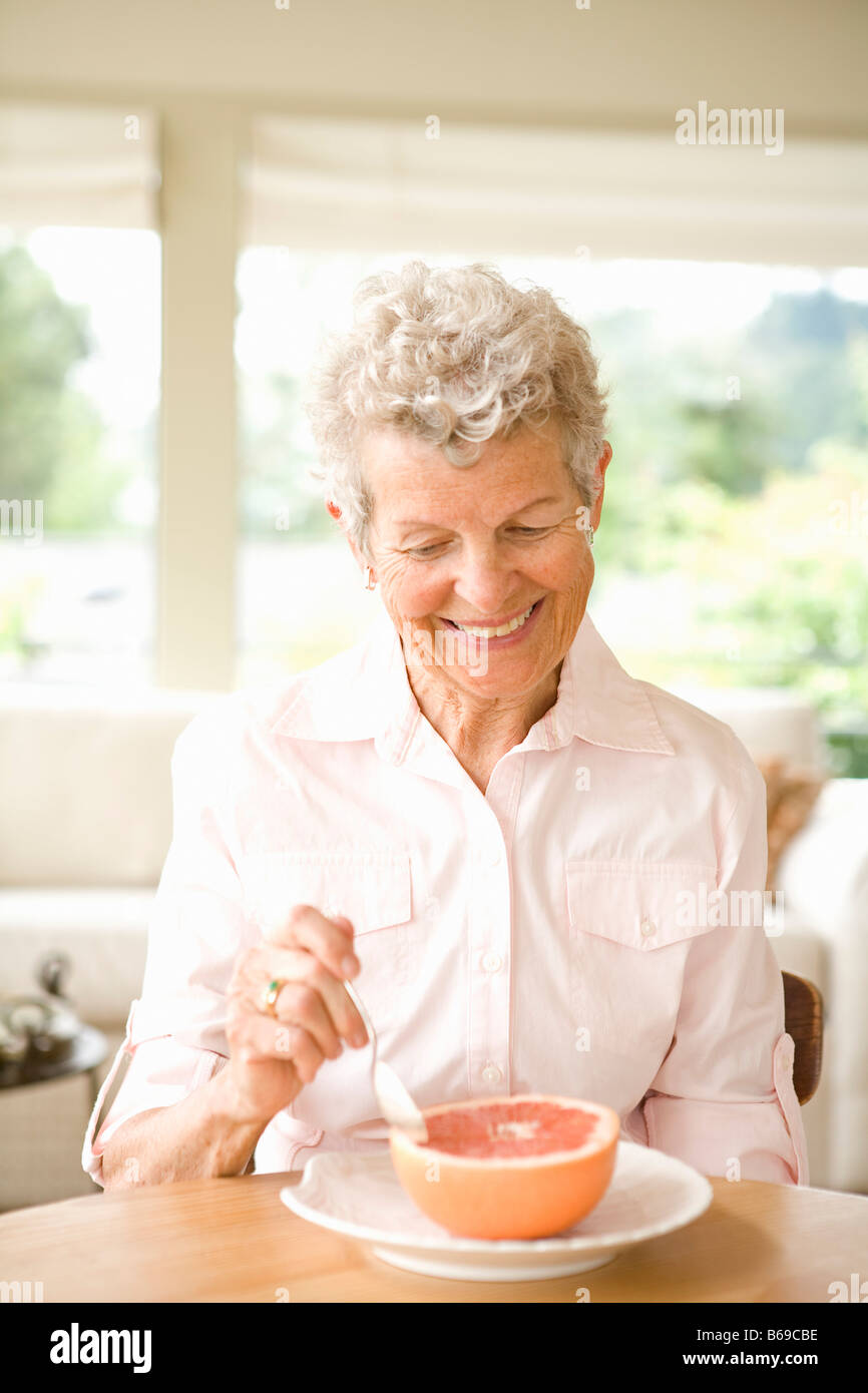 Woman eating a grapefruit Stock Photo - Alamy