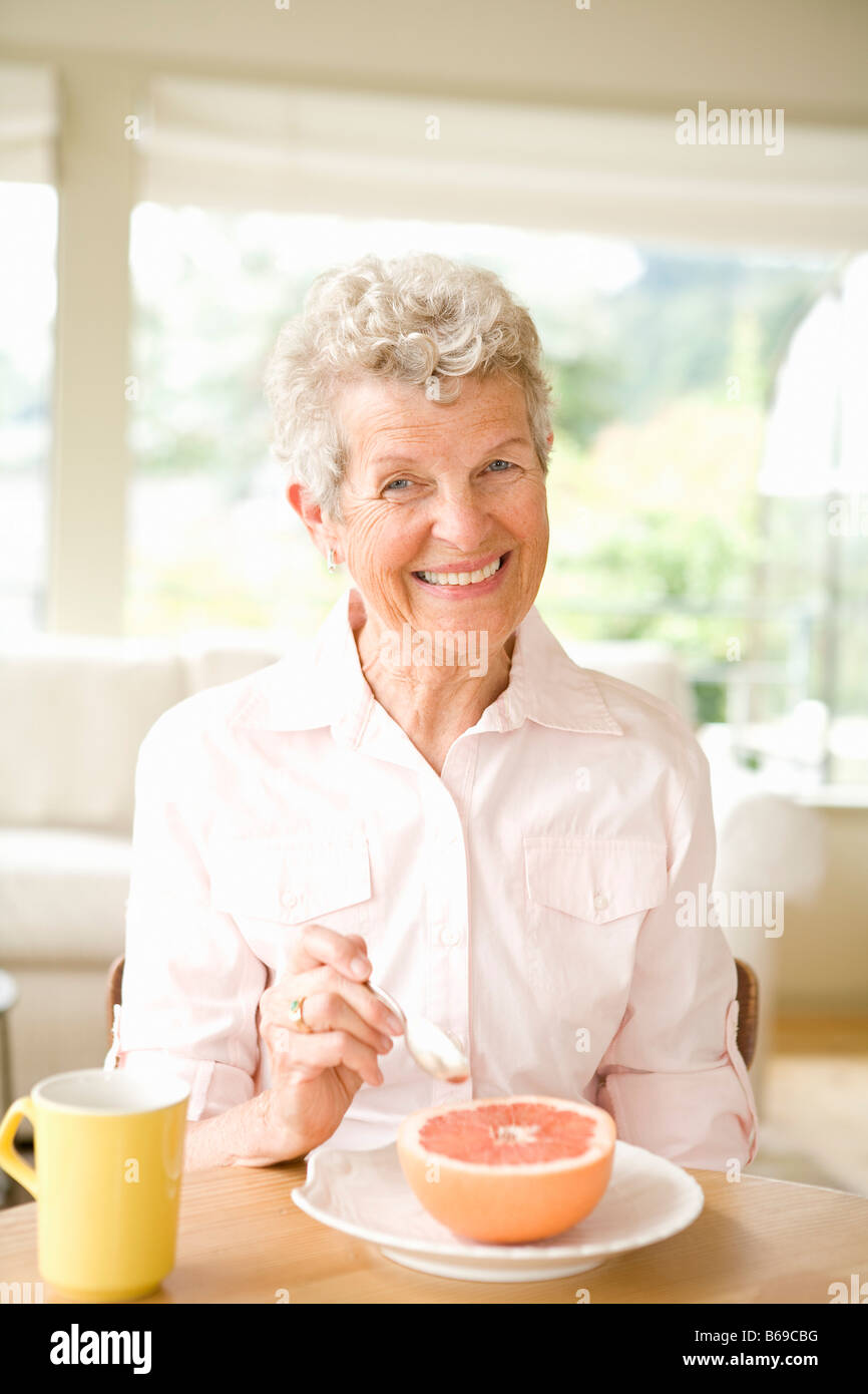 Woman eating a grapefruit Stock Photo - Alamy