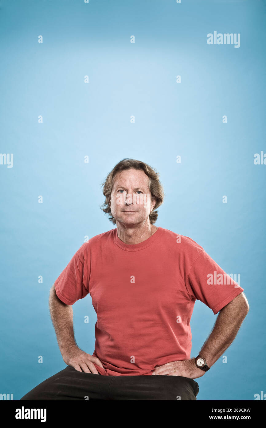 Portrait of a man sitting with arms akimbo Stock Photo - Alamy