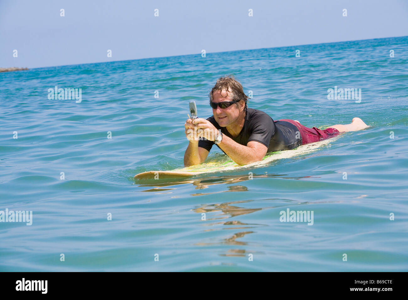 Man floating on water and text messaging Stock Photo - Alamy