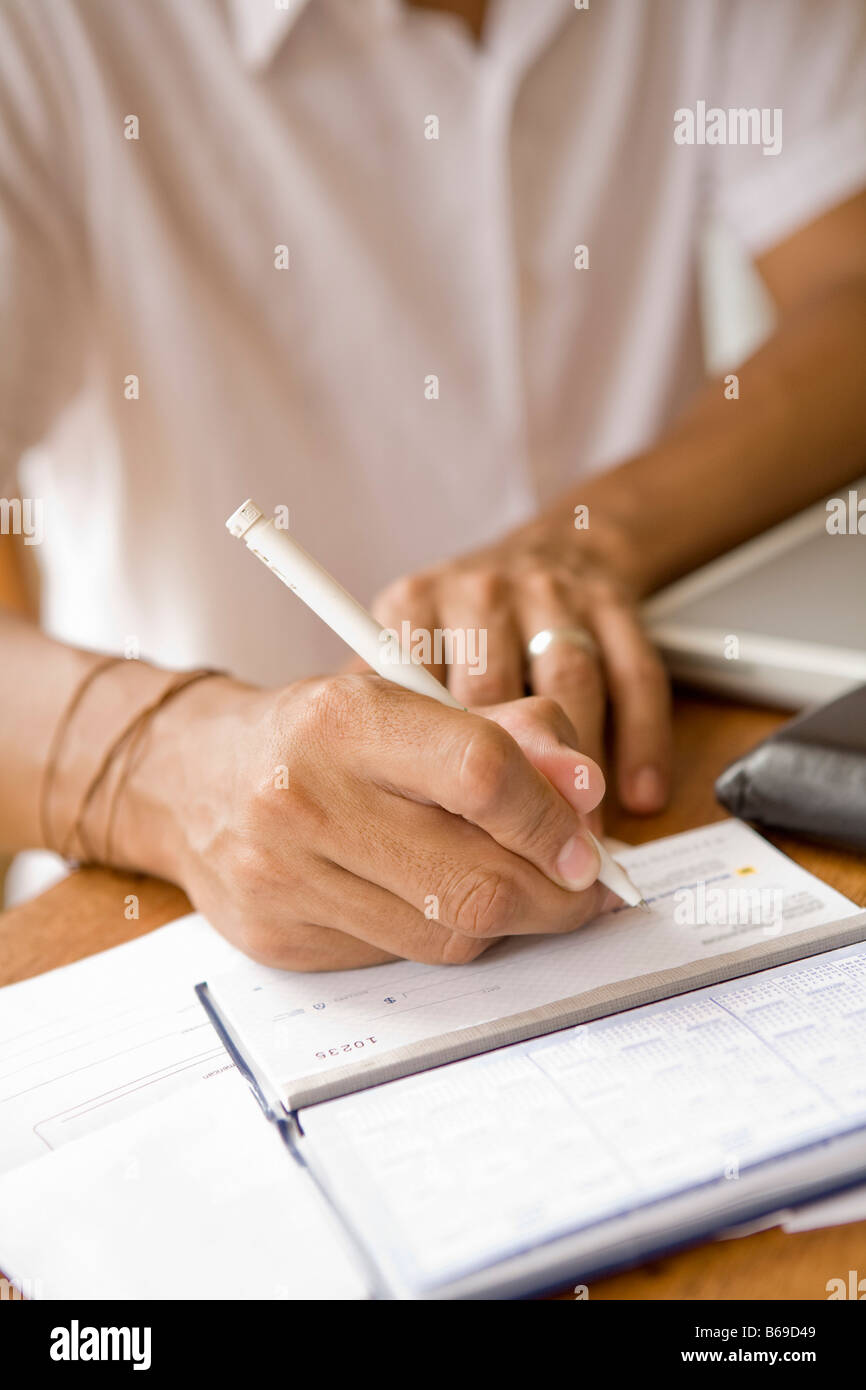 Man signing a check and preparing home finance budget Stock Photo - Alamy