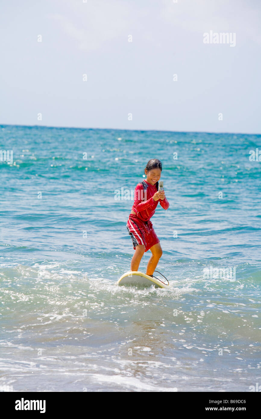 Girl surfing in the sea and using a mobile phone Stock Photo - Alamy