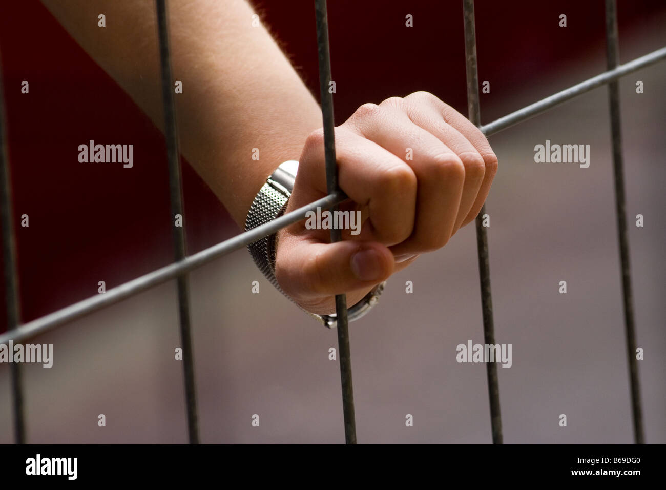 Hand holding on to iron bars Stock Photo - Alamy