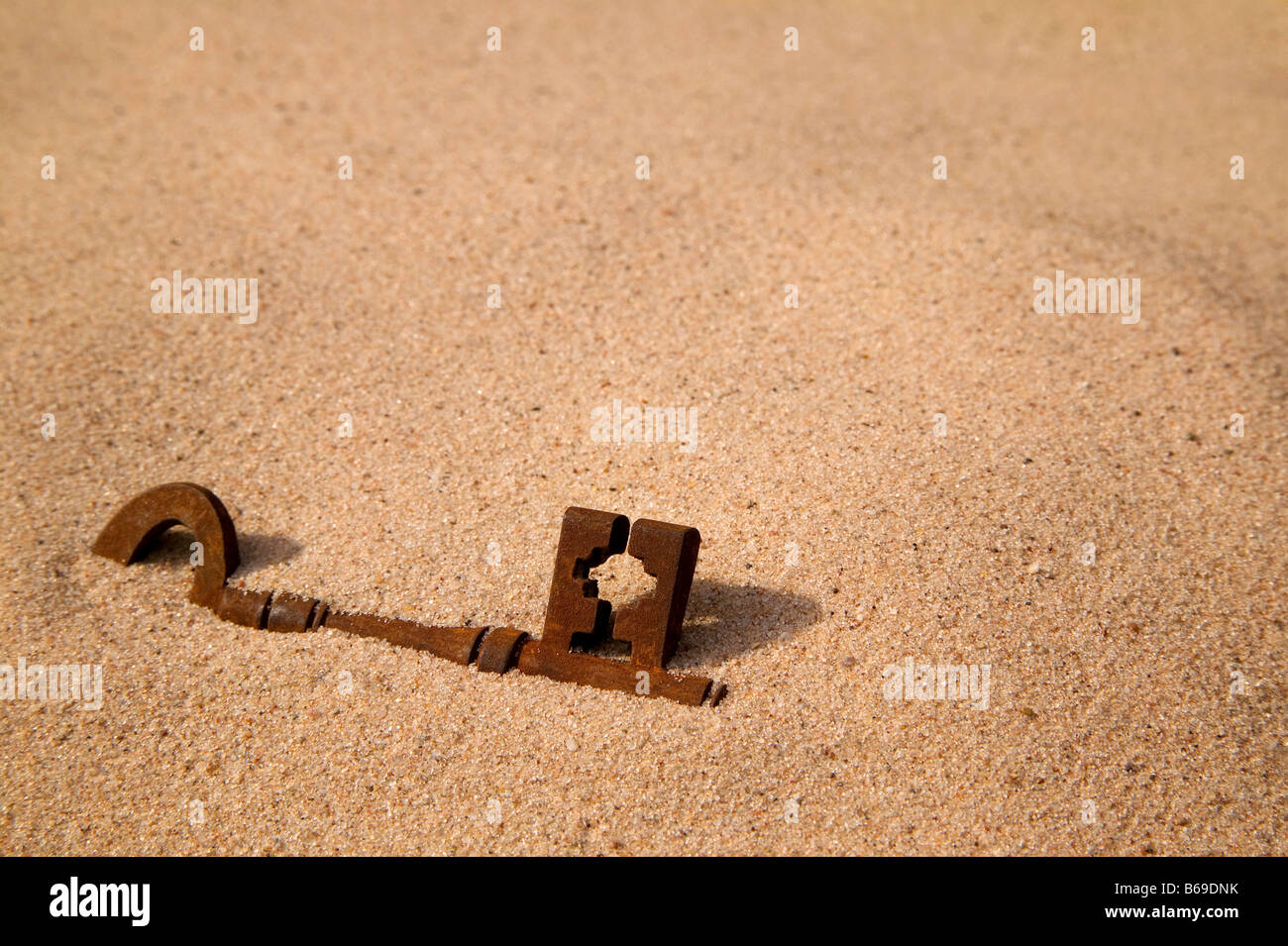 A rusty old key buried in the sand Stock Photo - Alamy