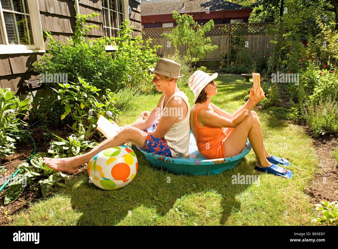Couple reading books in a wading pool Stock Photo - Alamy