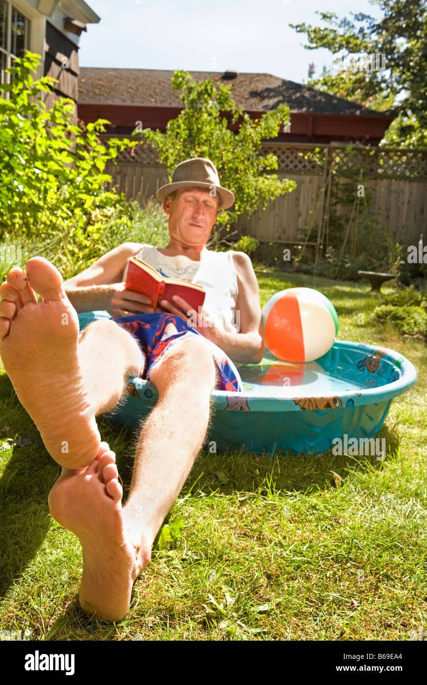 Man reading a book in a wading pool Stock Photo - Alamy