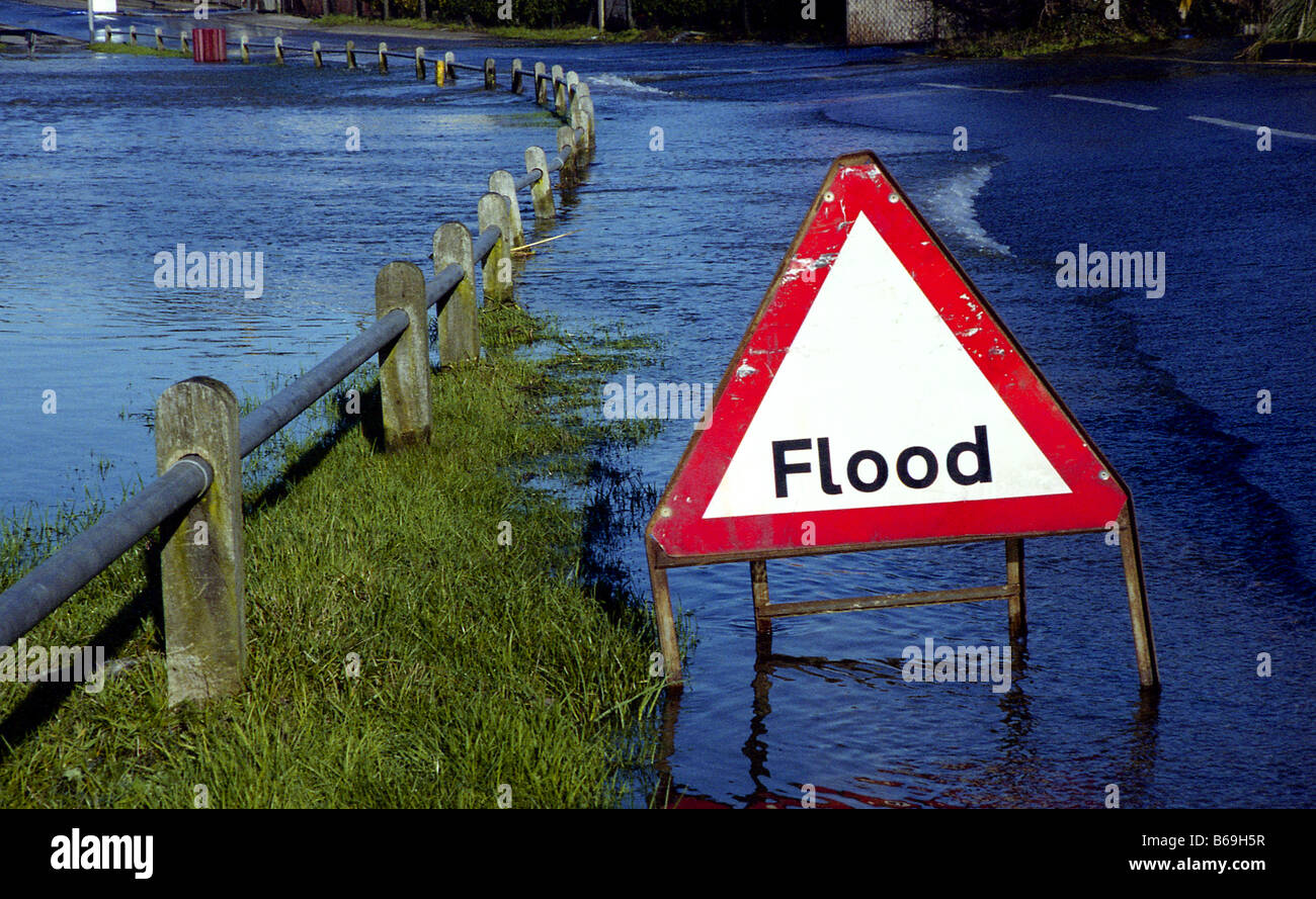 Flood warning sign with flooded road in background Stock Photo - Alamy