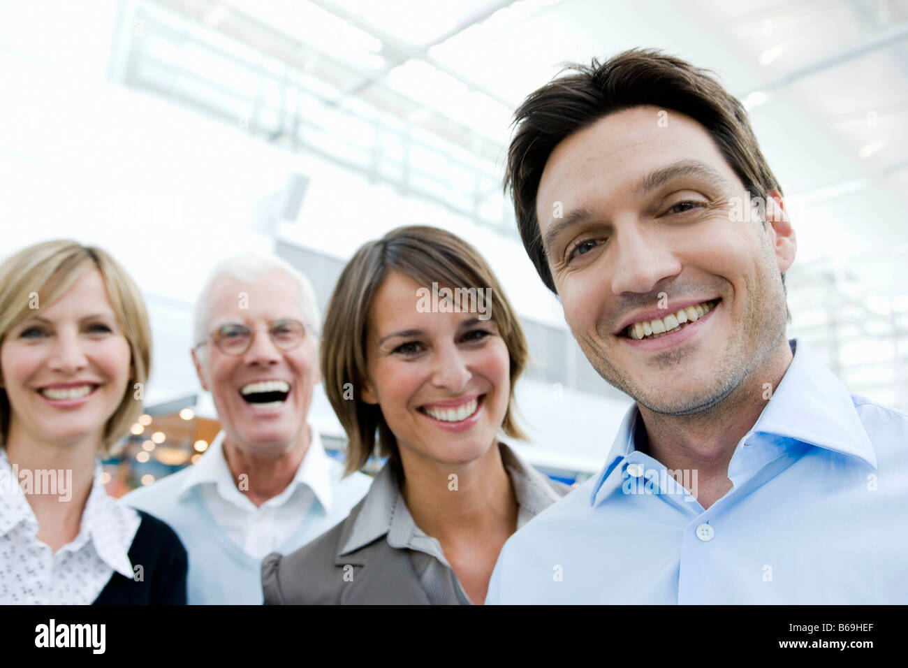 4 happy people looking at viewer Stock Photo - Alamy