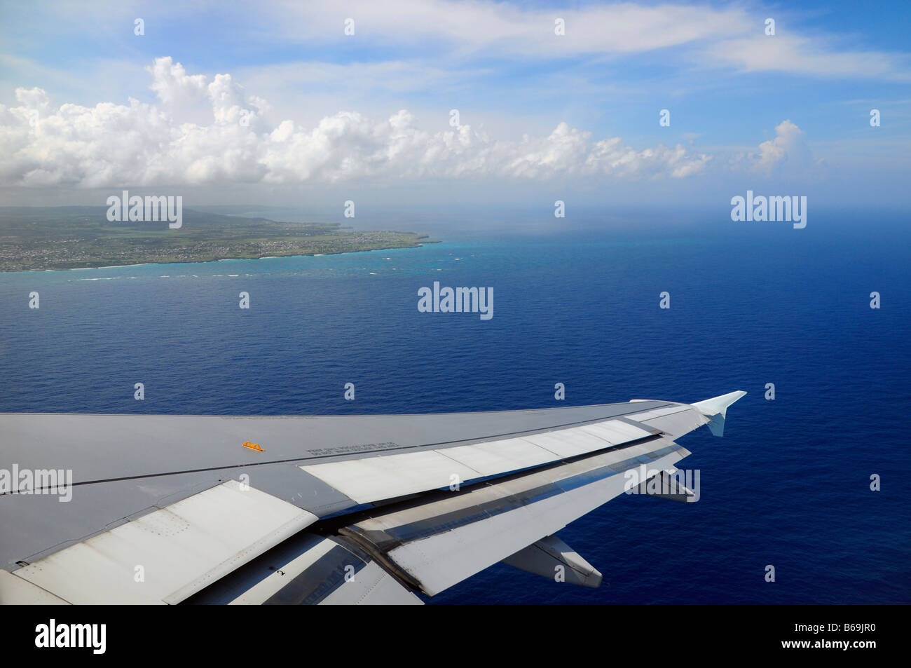 Airplane wing over Atlantic ocean and Barbados island in distance ...
