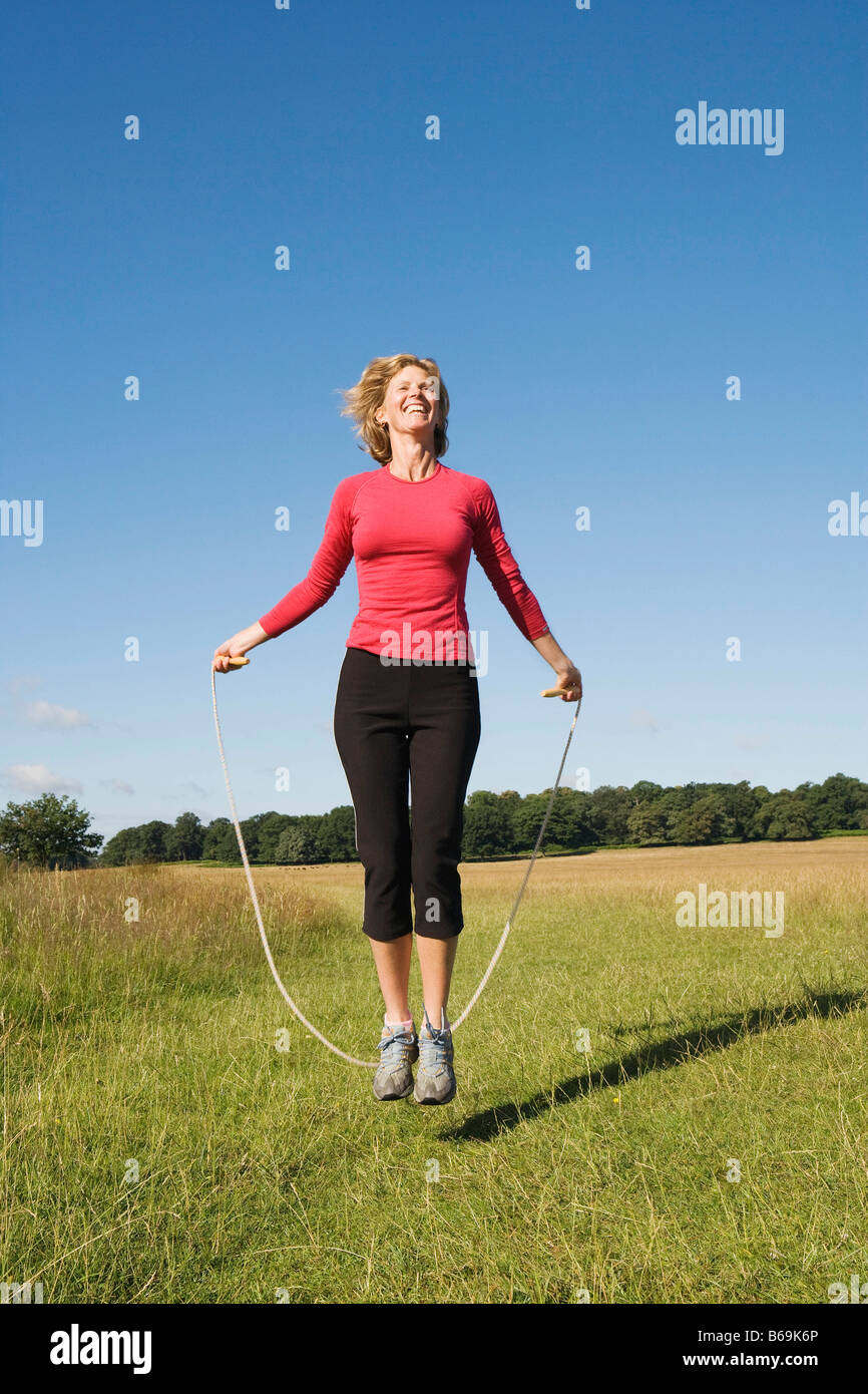 Woman skipping in field Stock Photo - Alamy
