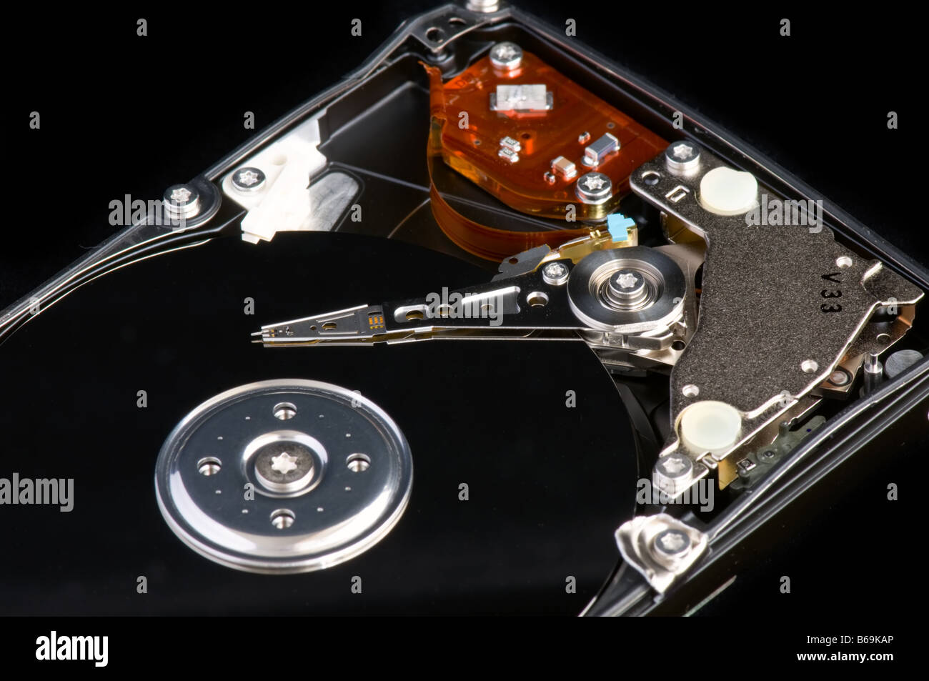Opened hard disk showing the disk surface and drive head over black ...