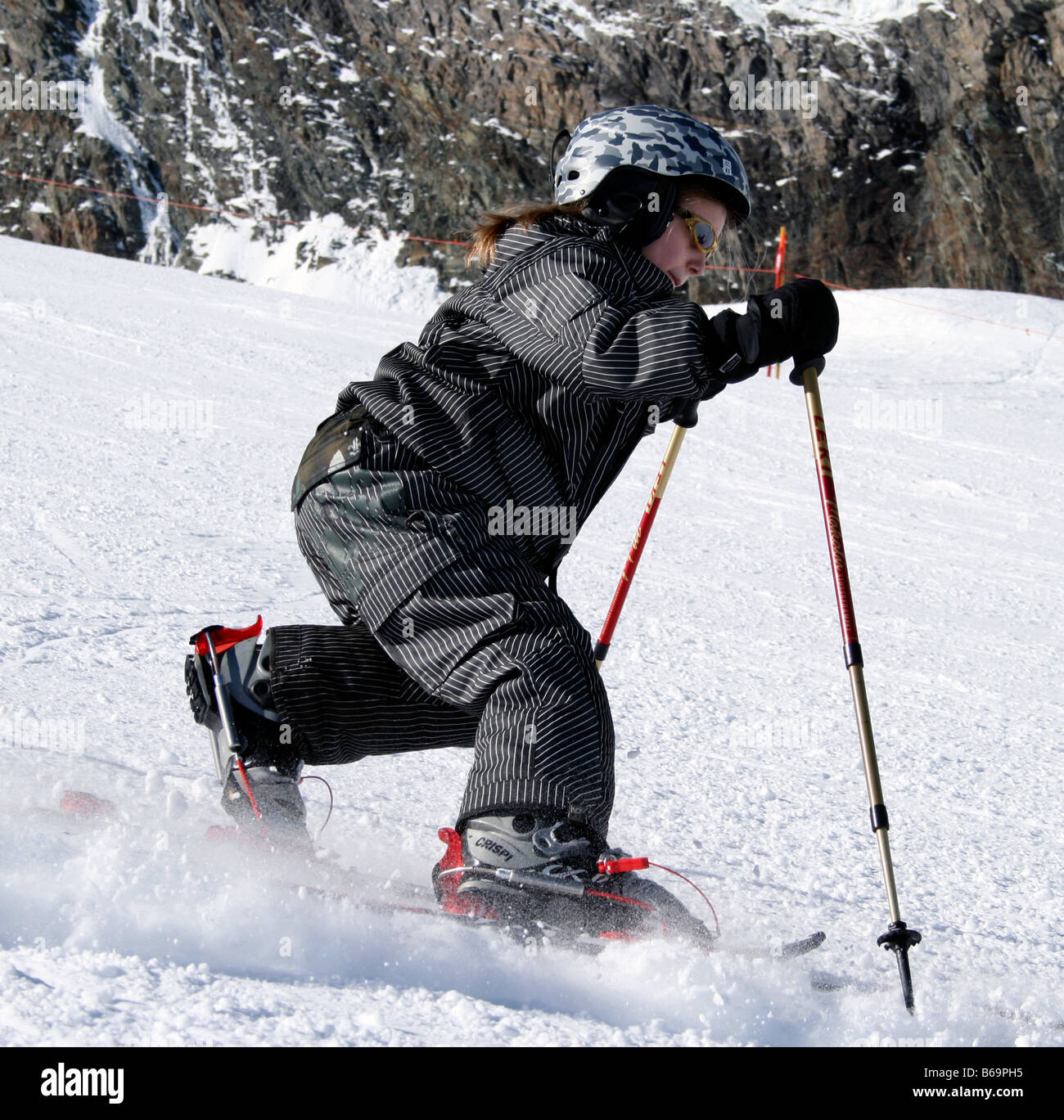 Nine year old girl skiing in Telemark style on the slopes of Saas Fee ...